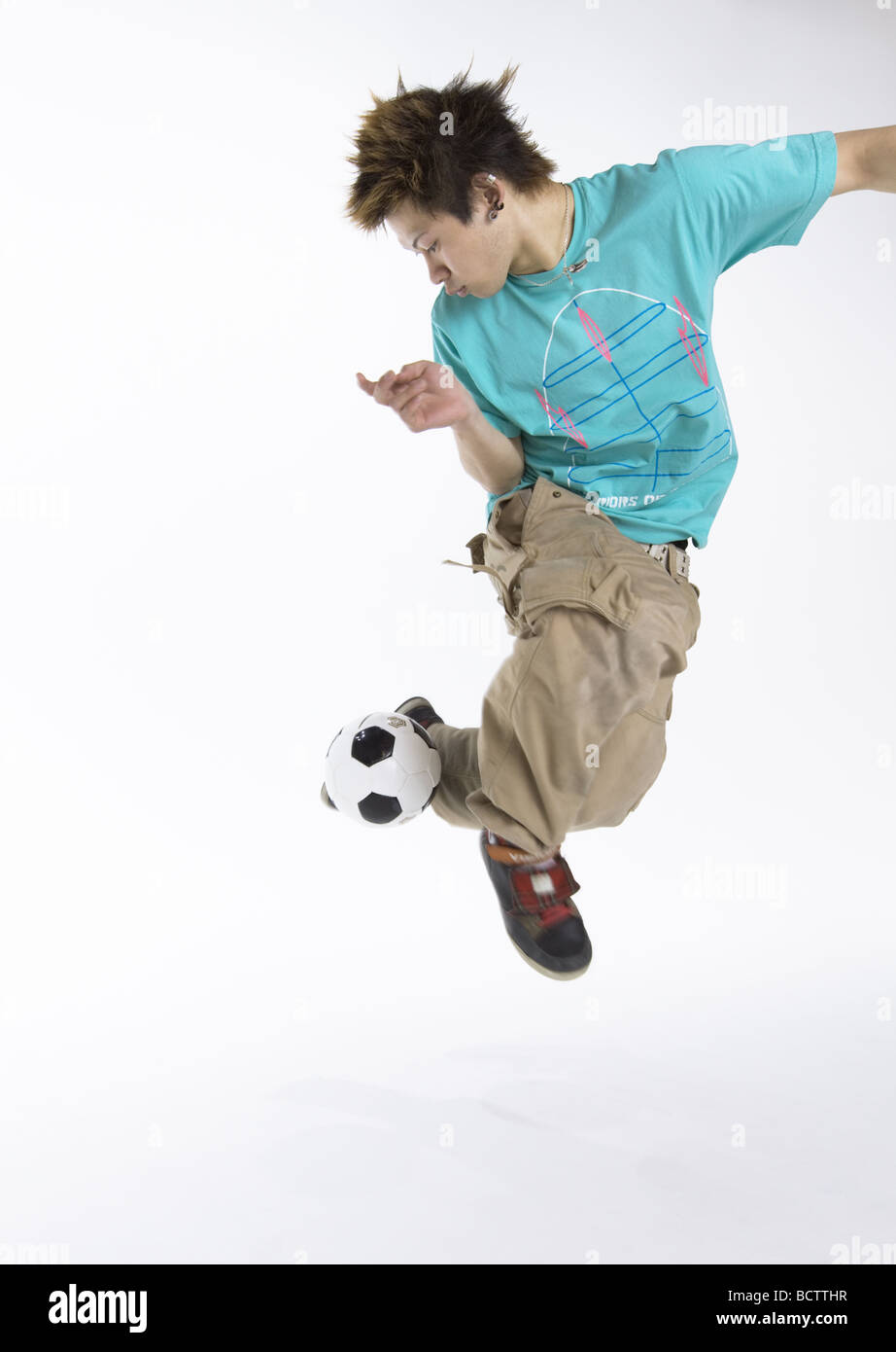 Young man playing soccer Stock Photo - Alamy