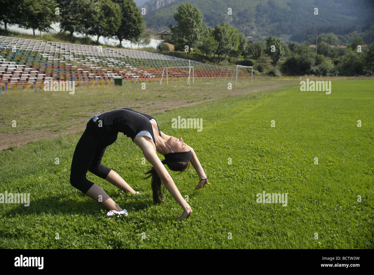 Girl doing back bridge yoga position outdoors Stock Photo - Alamy