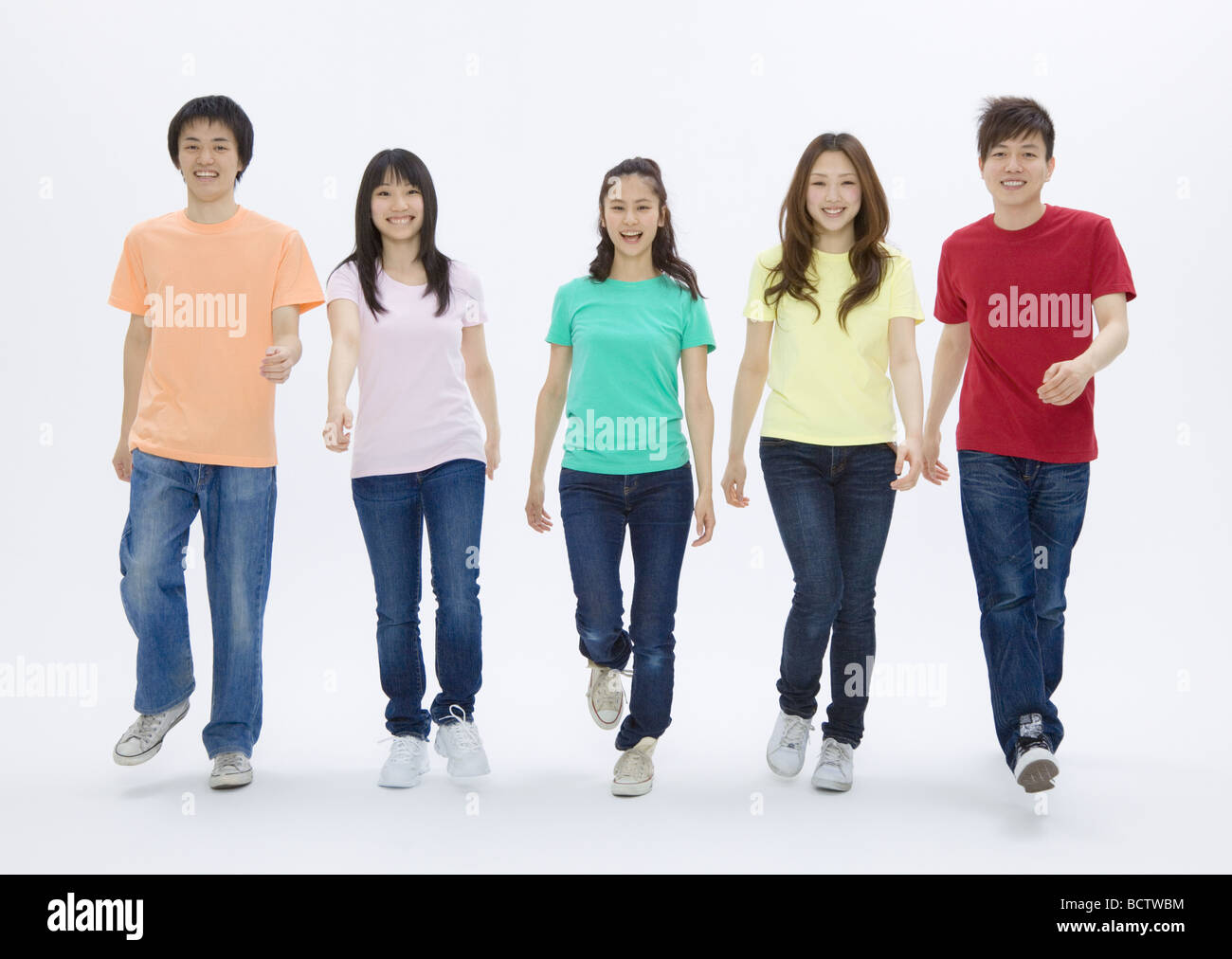 Young men and women walking in a row Stock Photo - Alamy