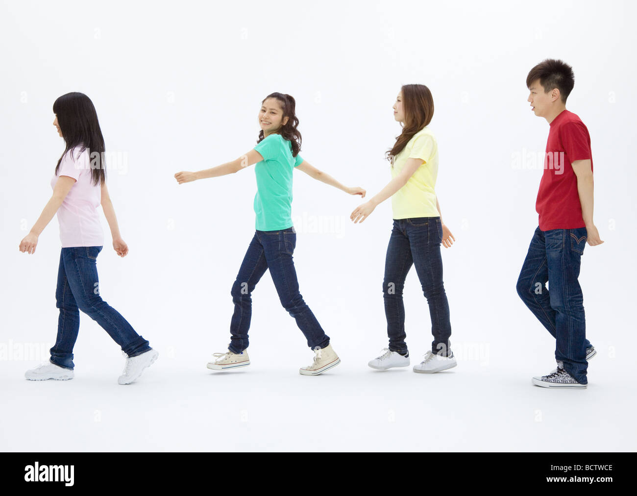 Young men and women walking in a row Stock Photo - Alamy