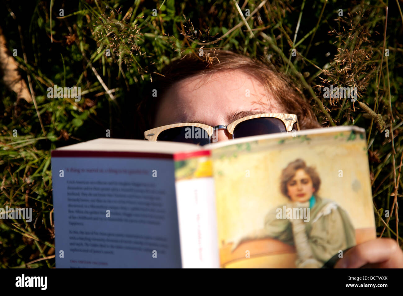 Girl reading outside in the park Stock Photo - Alamy