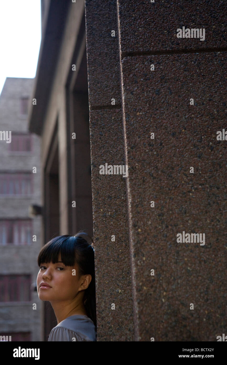 Portrait of a young woman leaning against a wall Stock Photo - Alamy