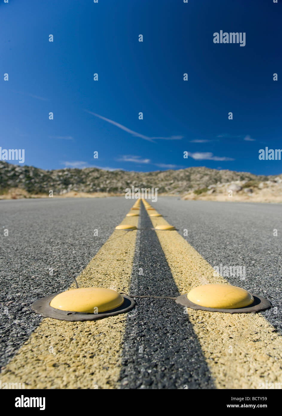 Lane markers on yellow dividing lines on a desert road Stock Photo - Alamy
