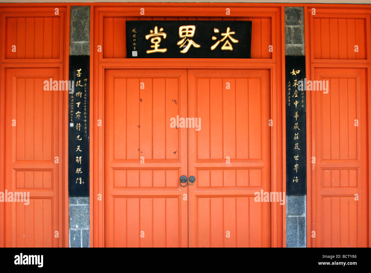 A orange coloured door displays a sign in Chinese writing that leads to ...