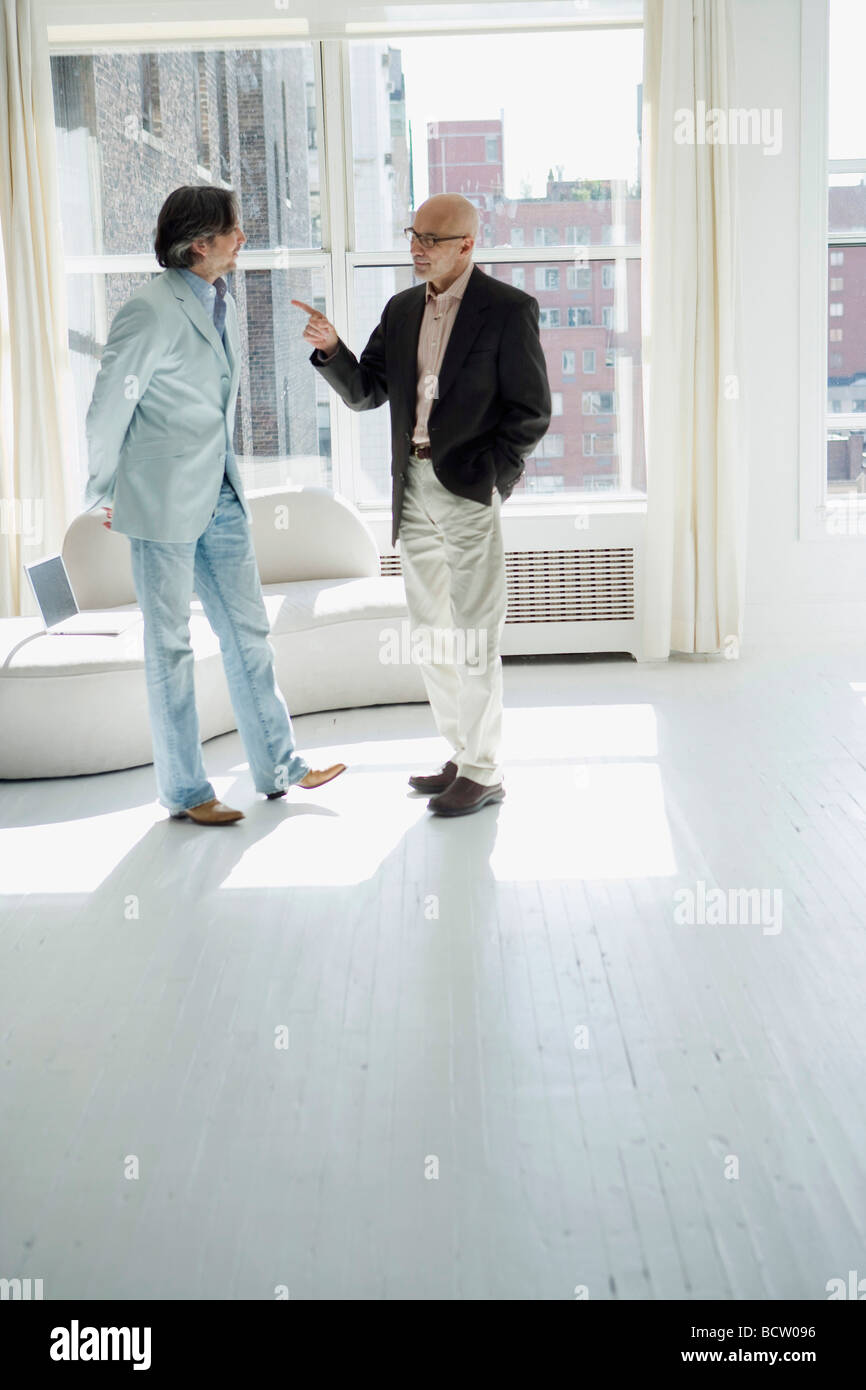 Two businessmen standing and talking Stock Photo - Alamy