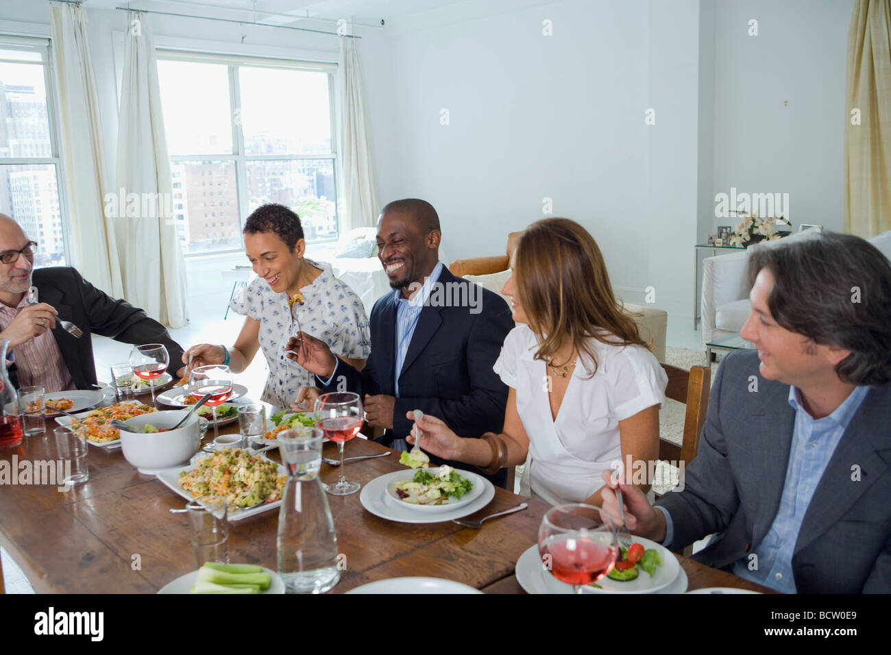 Friends sitting at the dining table Stock Photo - Alamy