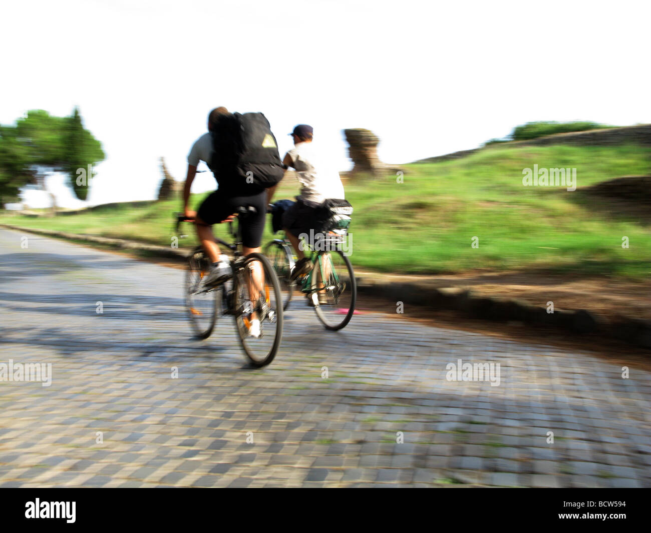 person riding bike on the ancient roman old appian way, rome, italy ...