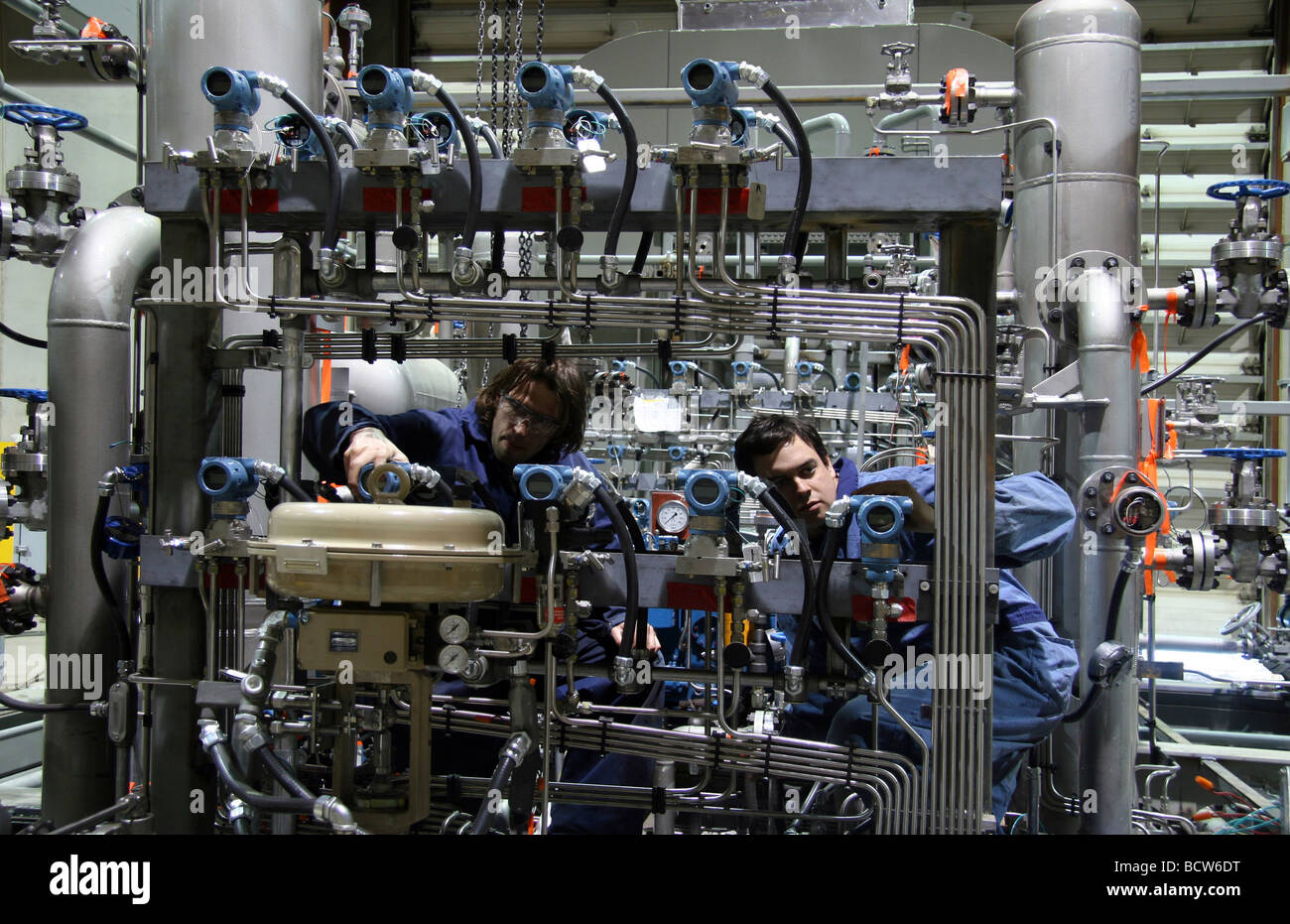 Two engineers working on a gas compressor machine Stock Photo - Alamy