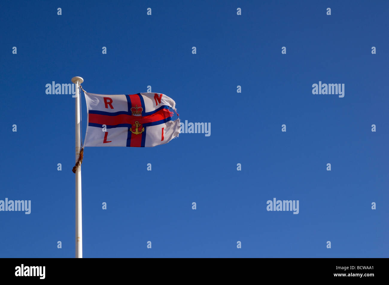 RNLI flag flying with blue sky background Stock Photo - Alamy