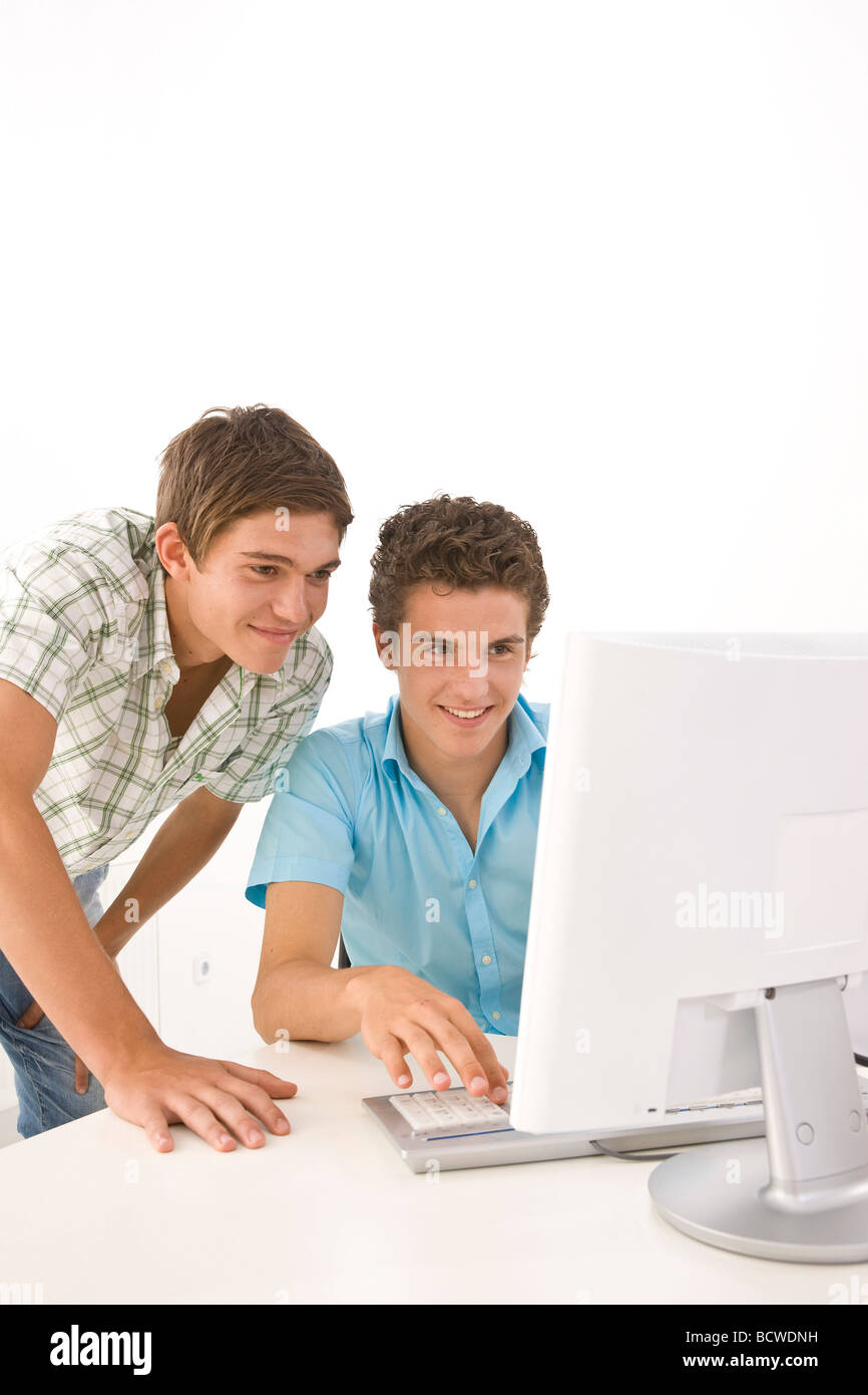 Two boys working on a computer Stock Photo - Alamy