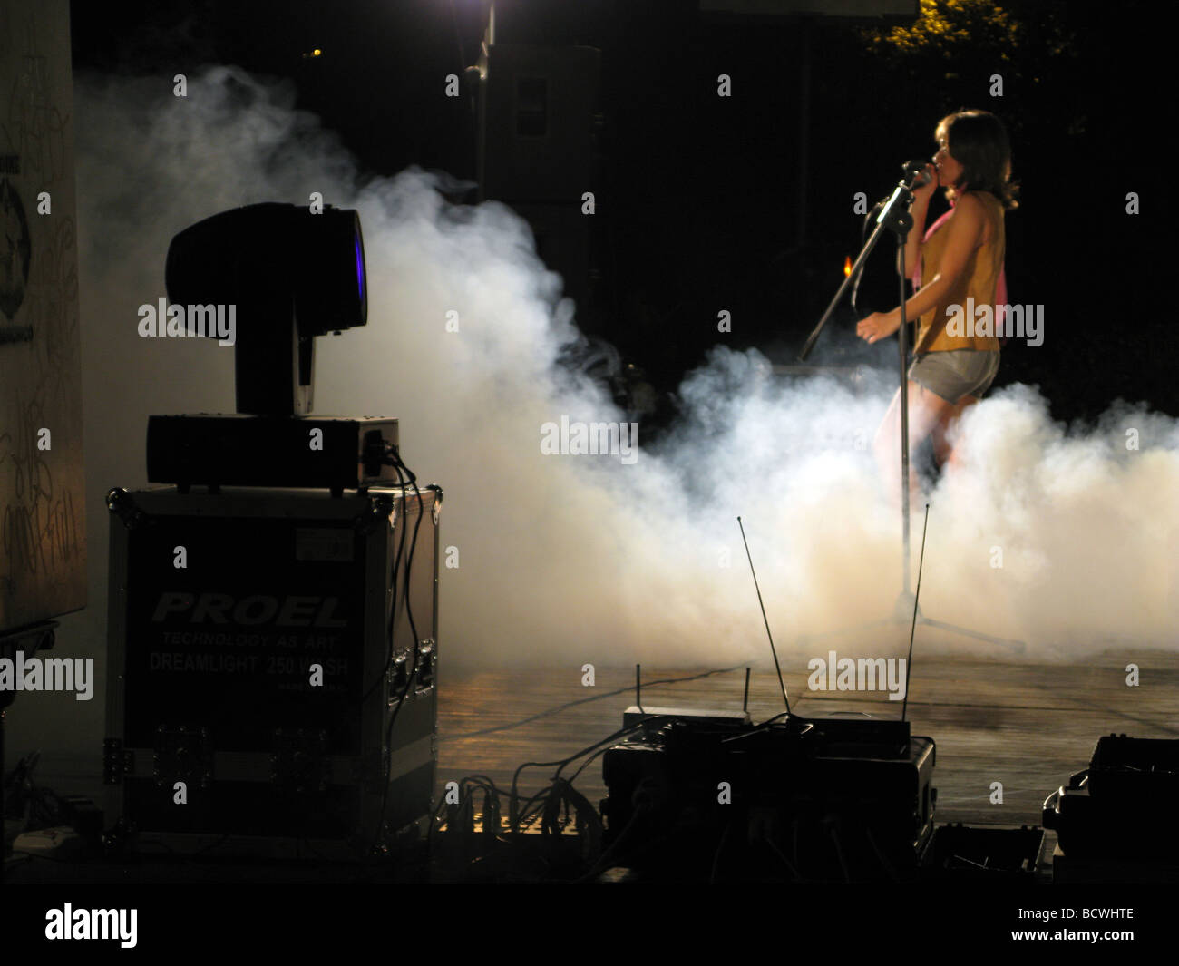 female singer on stage with smoke effect screen at night Stock Photo ...