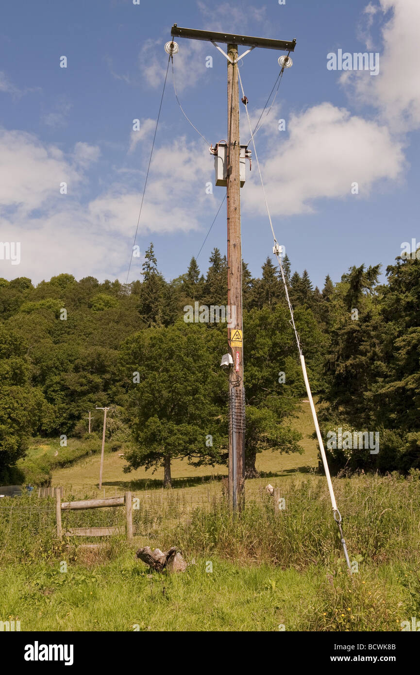 Single wooden electricity power mast placed in rural setting alongside ...