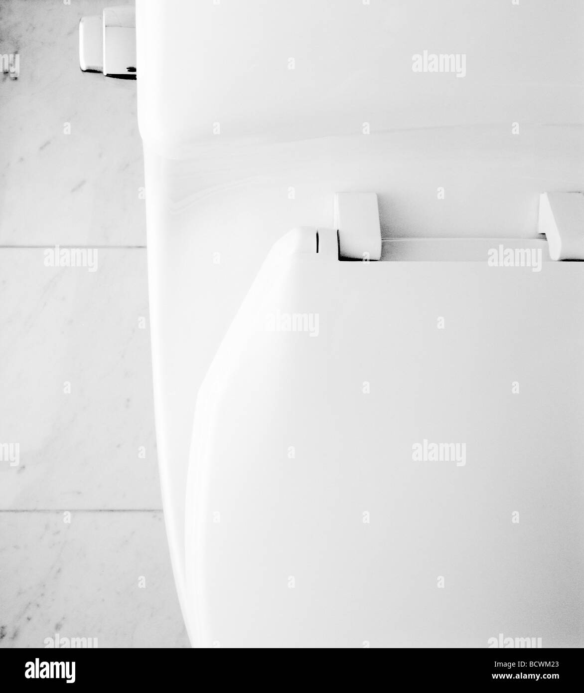 A quiet flush, low profile toilet detail shot from above in black and ...