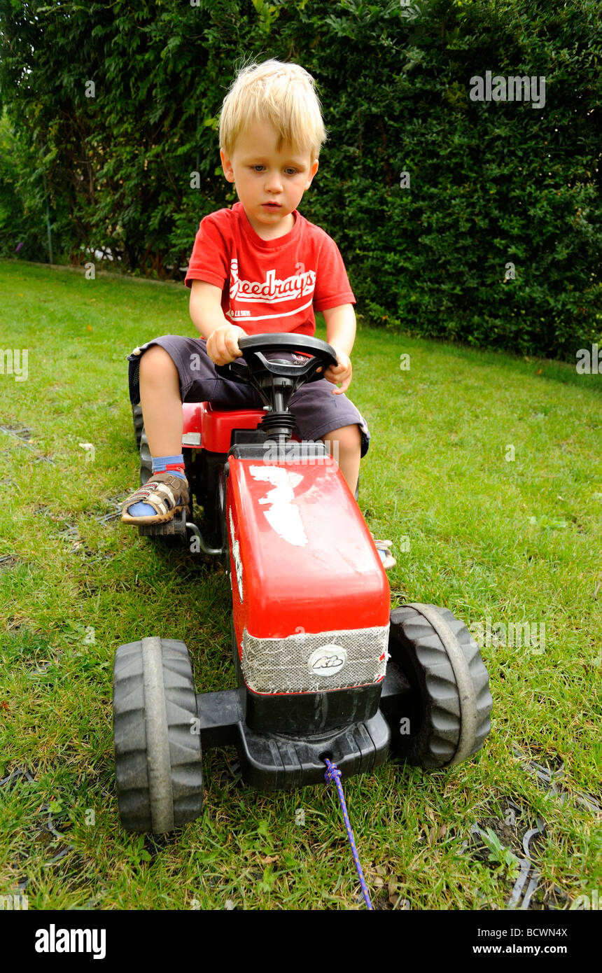 Child blond Boy driving a toy plastic tractor Stock Photo - Alamy
