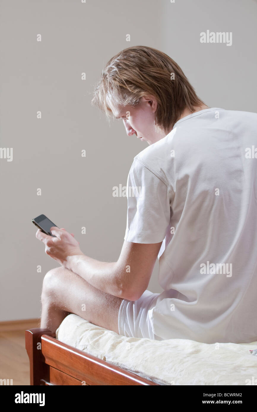 Young Man Sitting On Edge Bed High Resolution Stock Photography and ...
