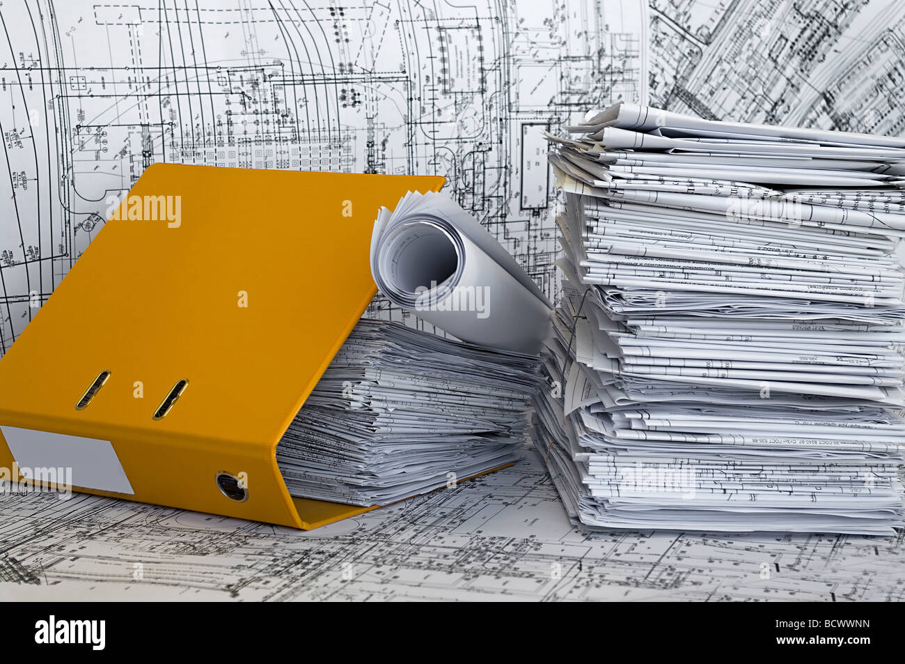 Yellow file folder and heap of design drawings are on the table ...