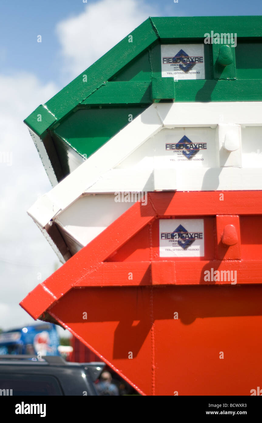 View of three coloured skips used for recycling stacked on top of each ...