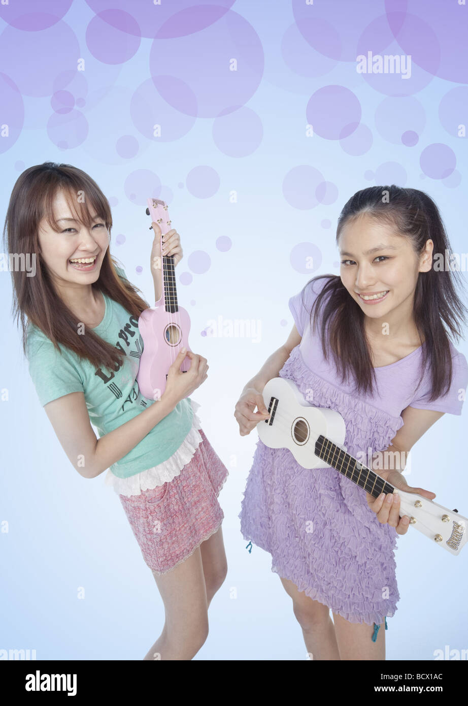 Young women playing the ukulele Stock Photo - Alamy