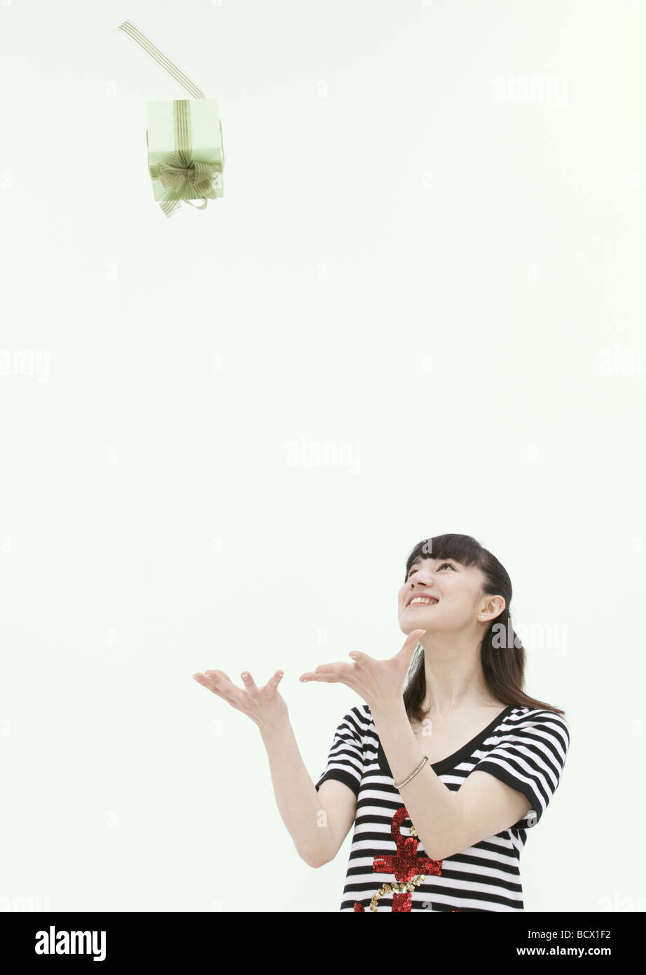 Young woman throwing present Stock Photo - Alamy
