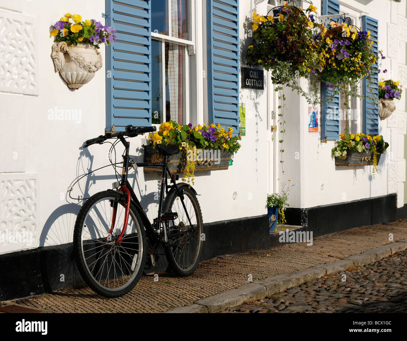 a bicycle outside a cottage in dartmouth devon, uk Stock Photo - Alamy