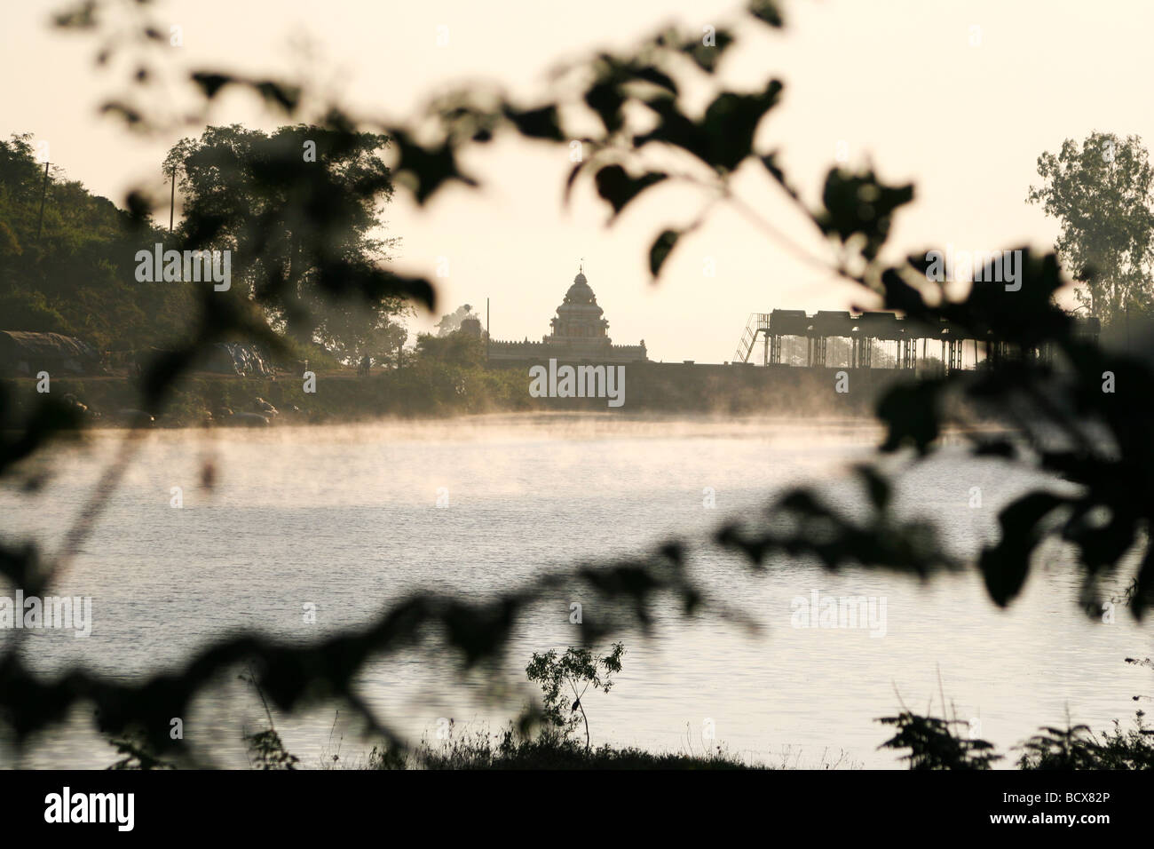 Looking through the branches of trees to the Bhadra Reservoir towards ...