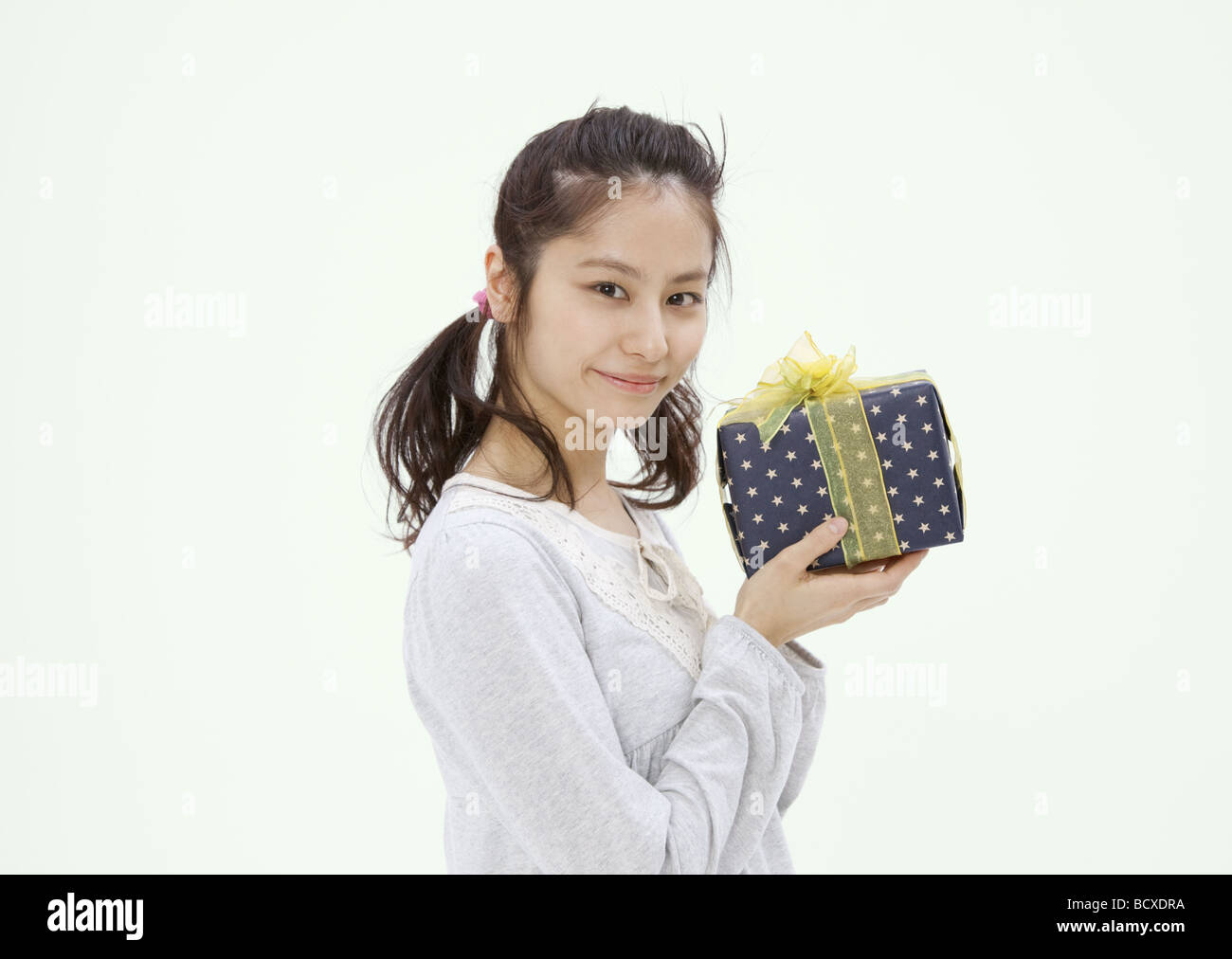 Young woman holding present Stock Photo - Alamy