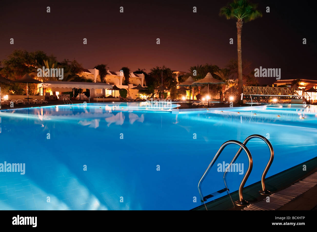 resort with pool at night view Stock Photo - Alamy