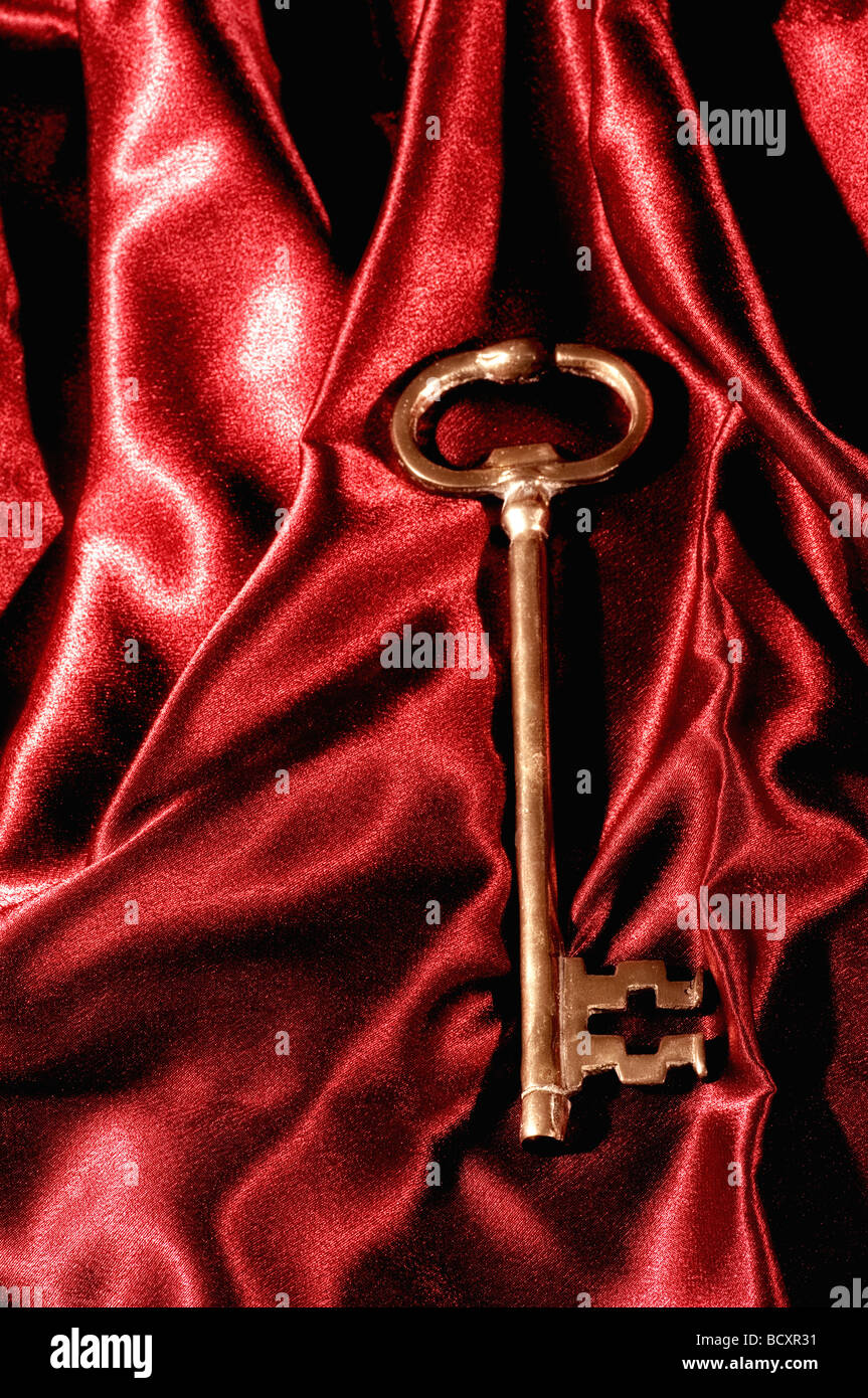 Antique key on red satin Stock Photo - Alamy