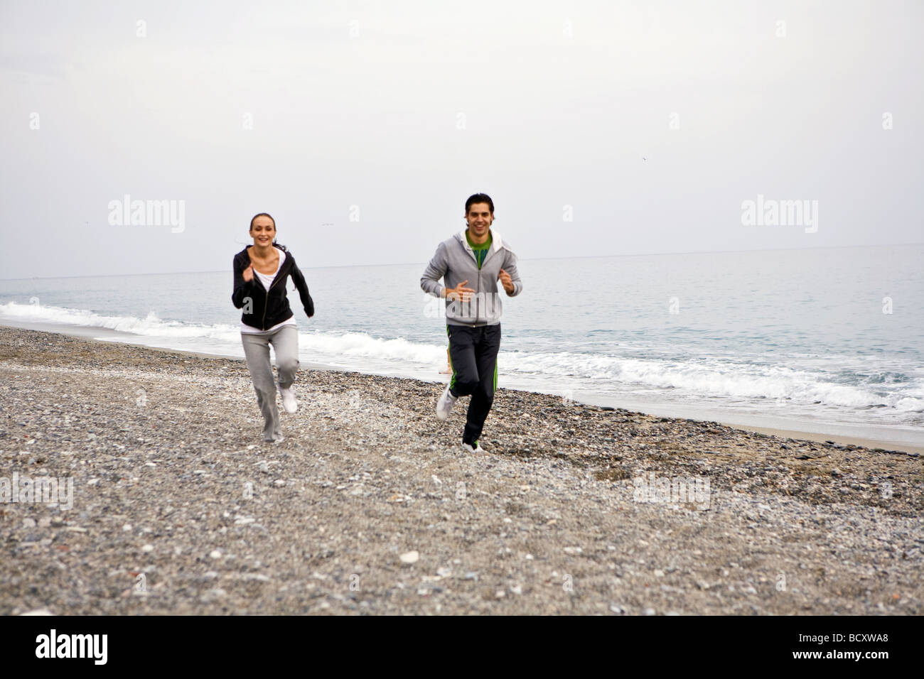 couple running on beach Stock Photo - Alamy