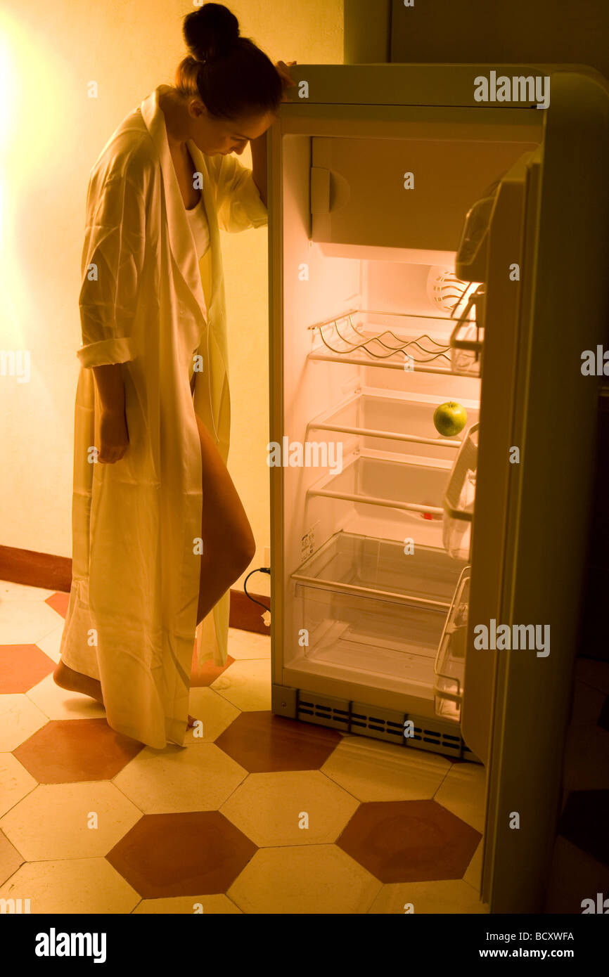 woman looking in fridge at night Stock Photo - Alamy