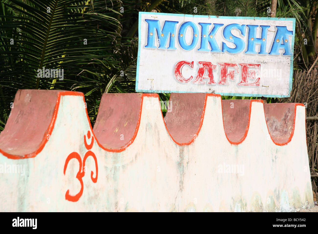 A wall at Om Beach in Karnataka, India. A faded sign for the Moksha ...