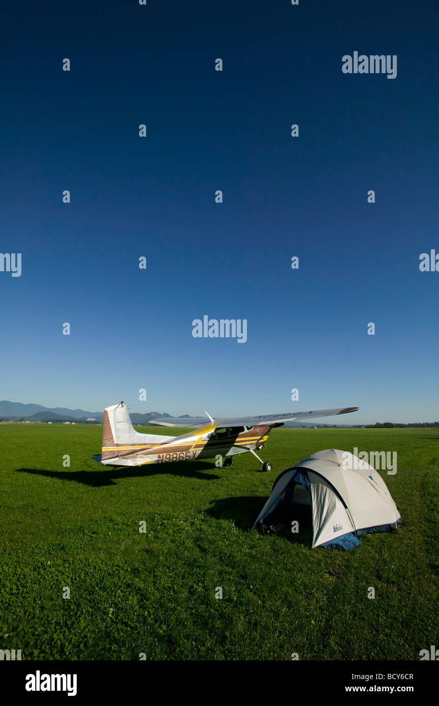 Small airplane parked on grass with tent beside Stock Photo - Alamy