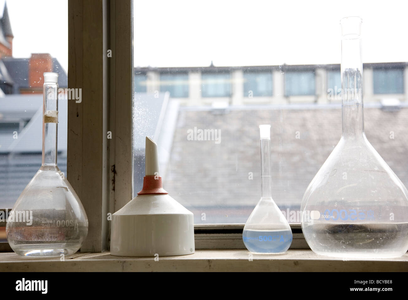 Glass beakers on window shelf Stock Photo - Alamy