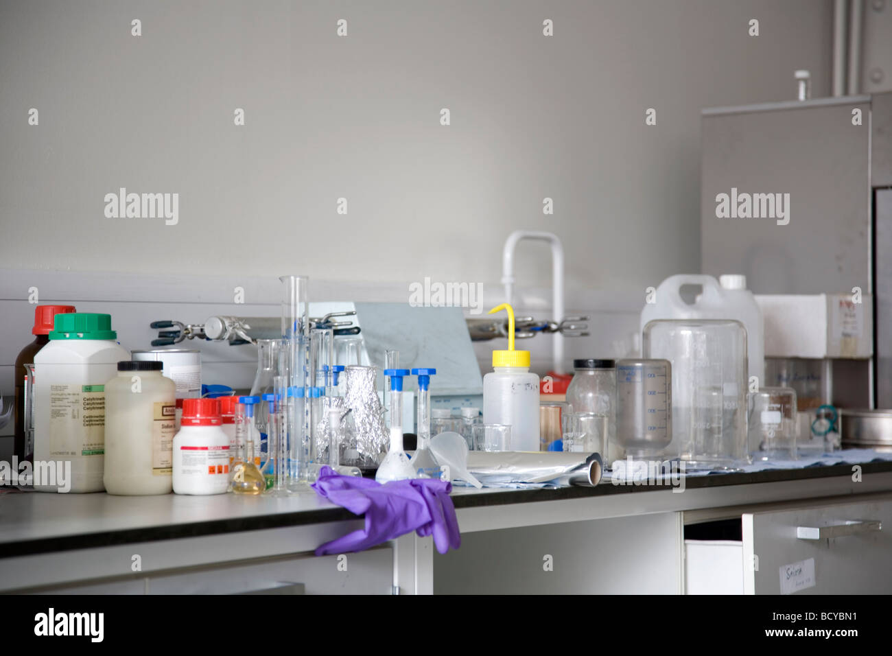 Lab shelf with bottles and tube - gloves - at work Stock Photo - Alamy