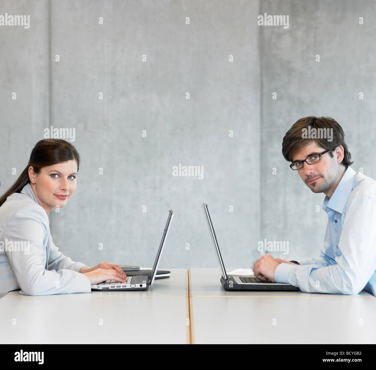 Two Businesspeople using laptops Stock Photo - Alamy