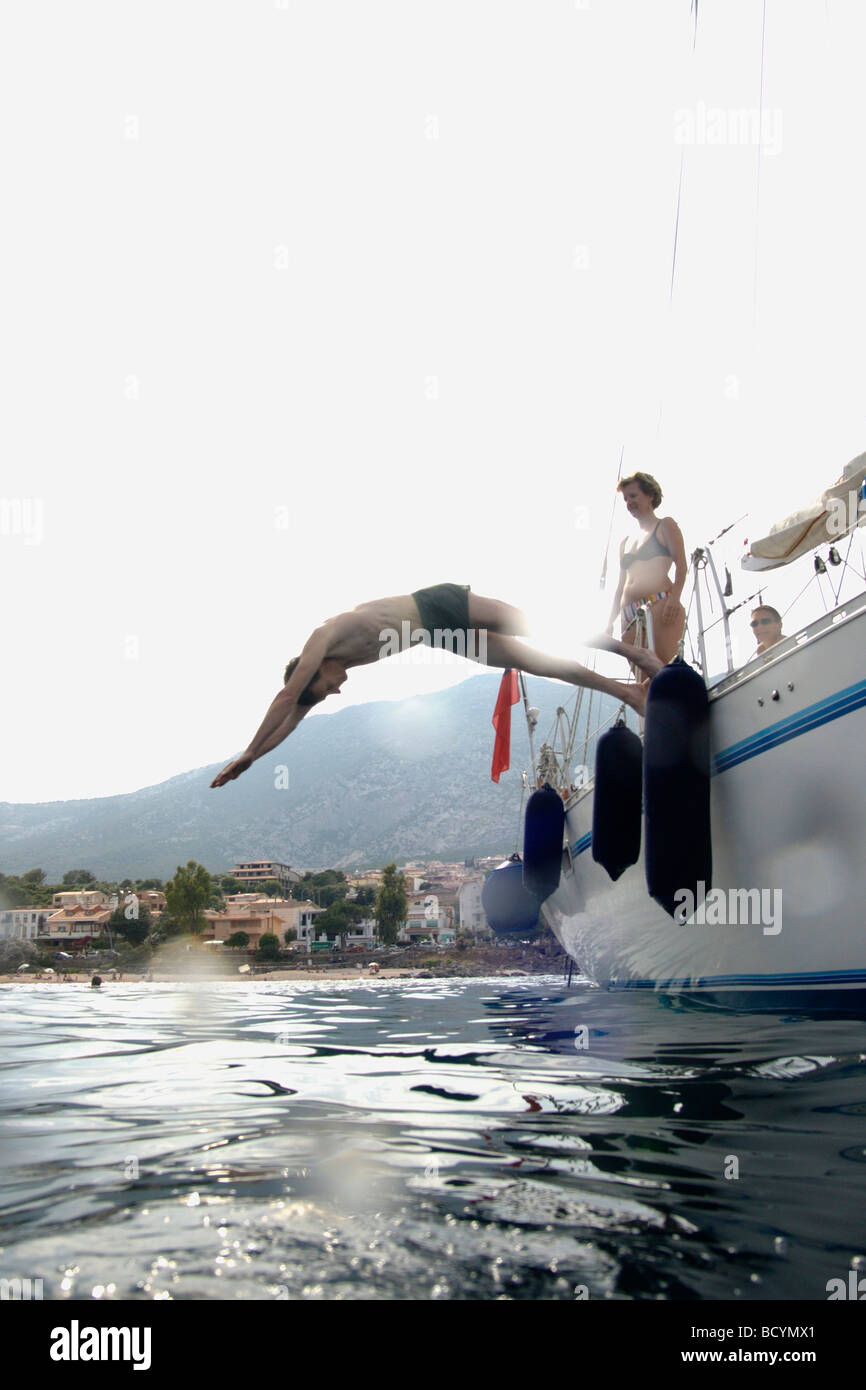 Man diving into water from sailing boat Stock Photo - Alamy