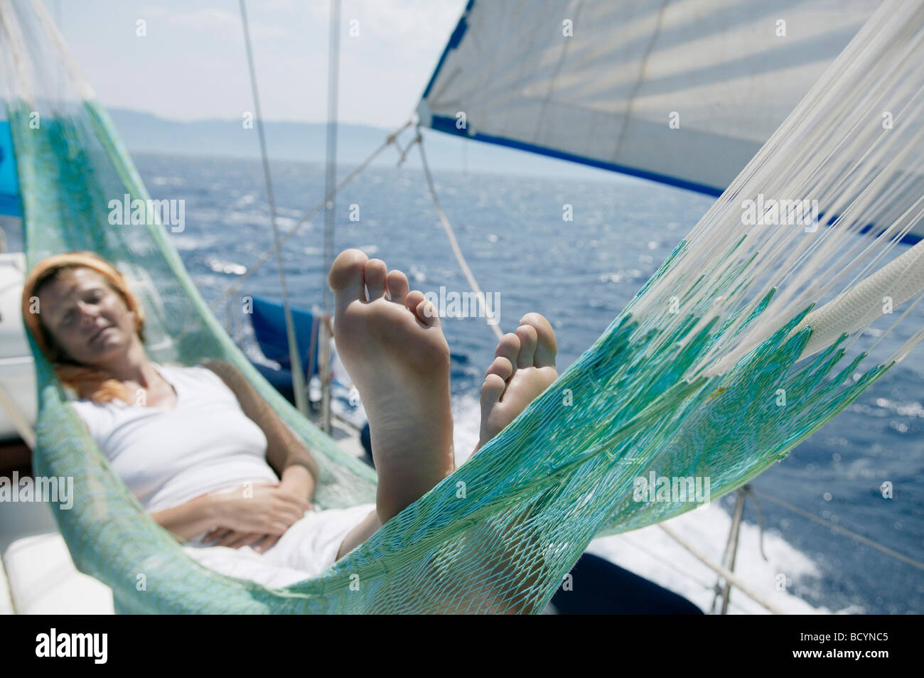 Woman lying in hammock on sailing boat Stock Photo - Alamy