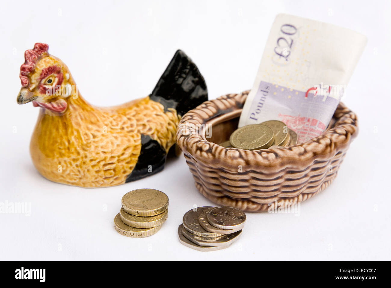 Coins are laid out next to a ceramic hen. A similar hen was used for ...