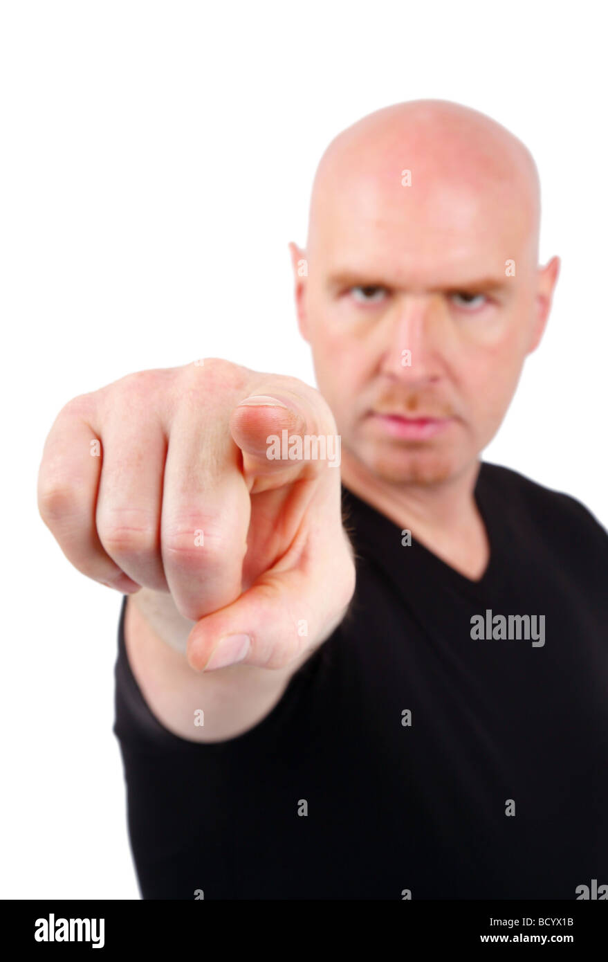 bald headed, young mean man is pointing with his finger into the camera ...