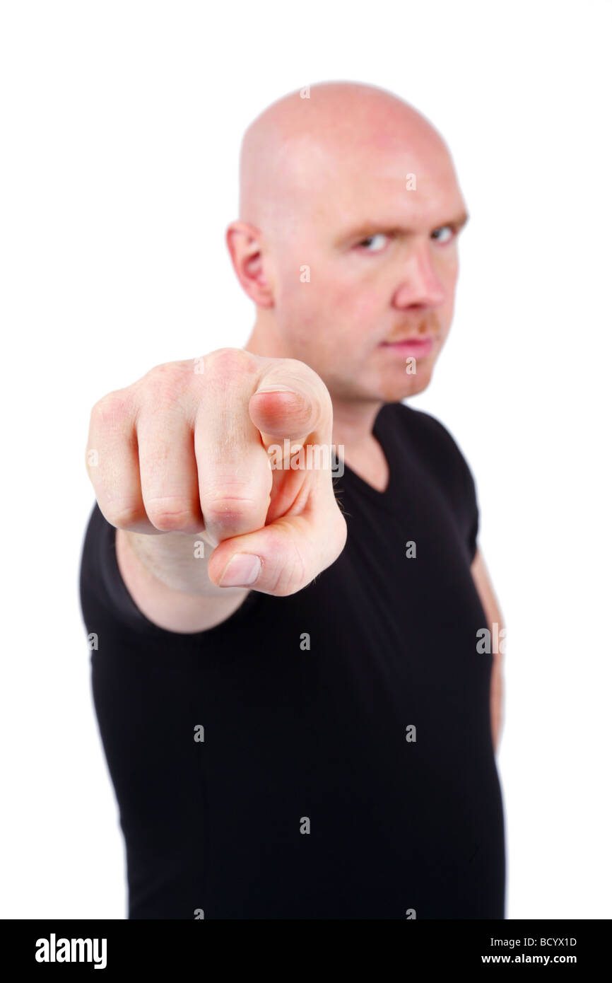 bald headed, young mean man is pointing with his finger into the camera ...