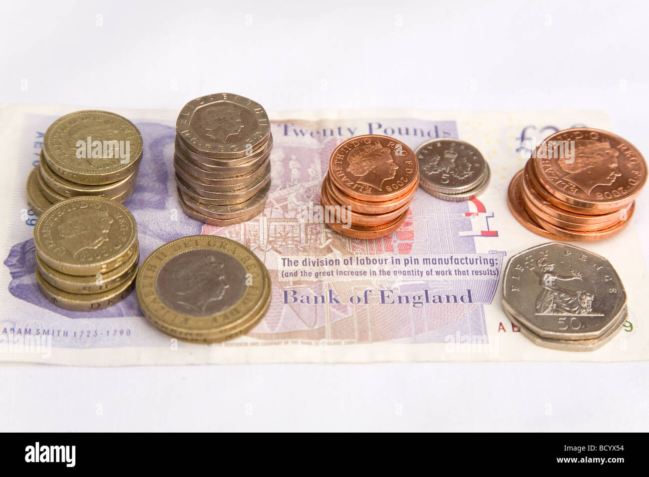 British coins of various denominations are laid out and stacked on top ...
