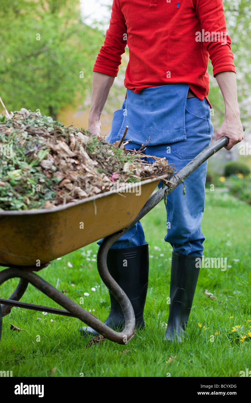 man pushing wheelbarrow Stock Photo - Alamy