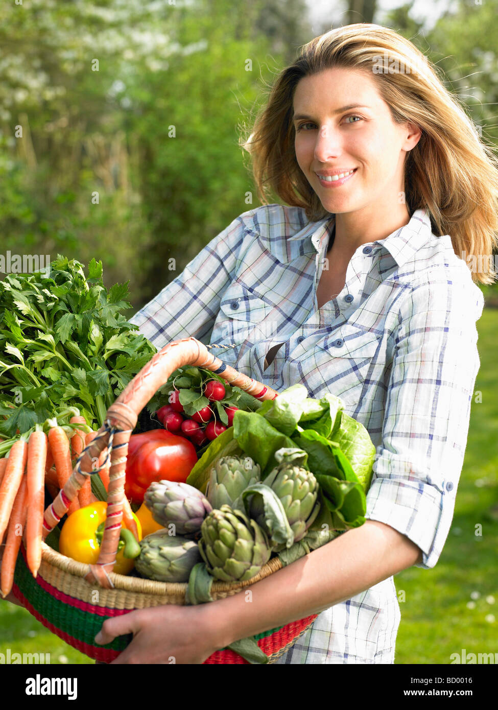 Woman holding a vegetable basket Stock Photo - Alamy
