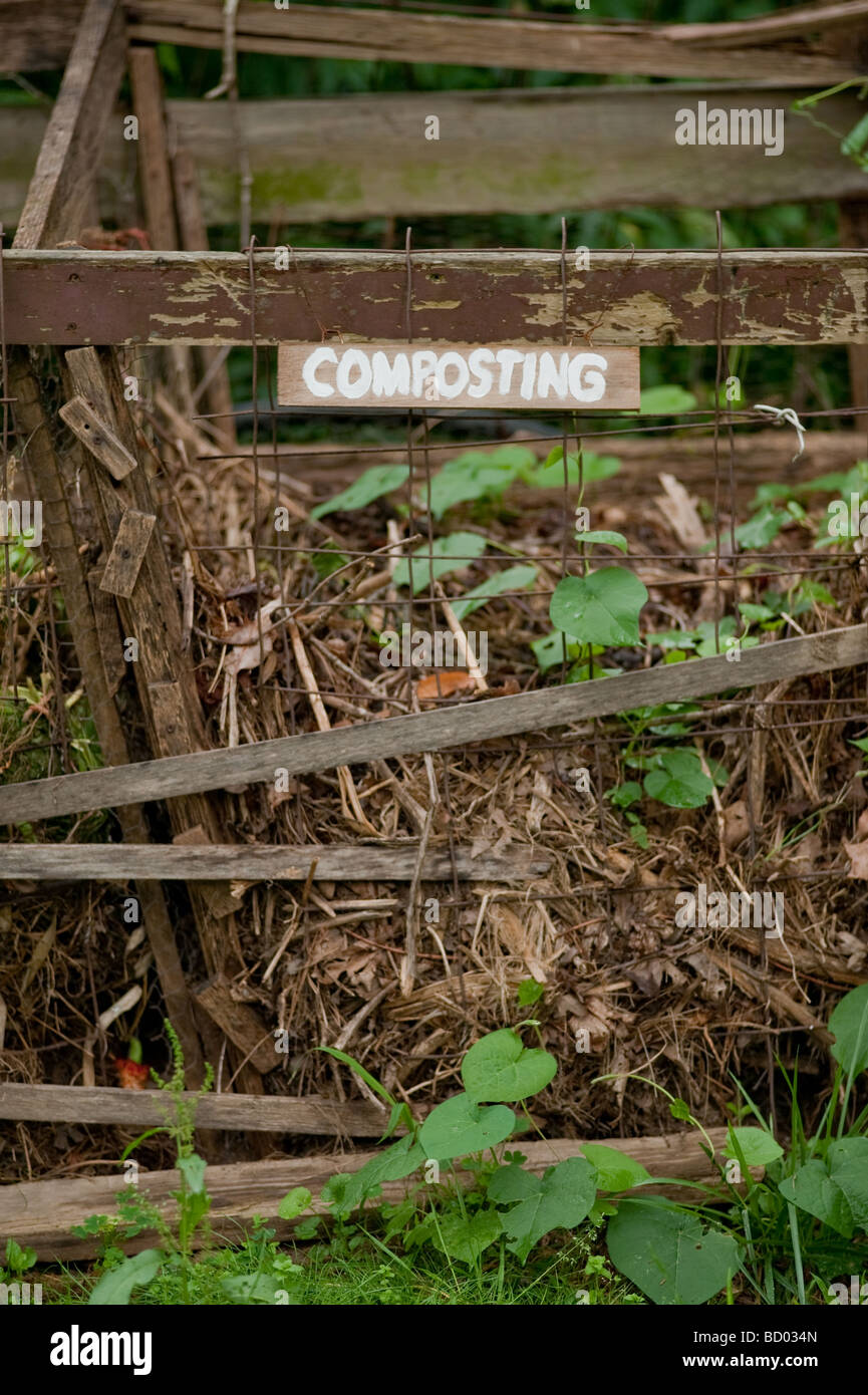 composting bin with leaves and other debris in it. It has a sign that ...