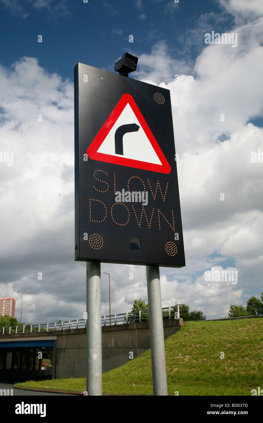 Slow Down road sign indicating a turn to the right Stock Photo - Alamy