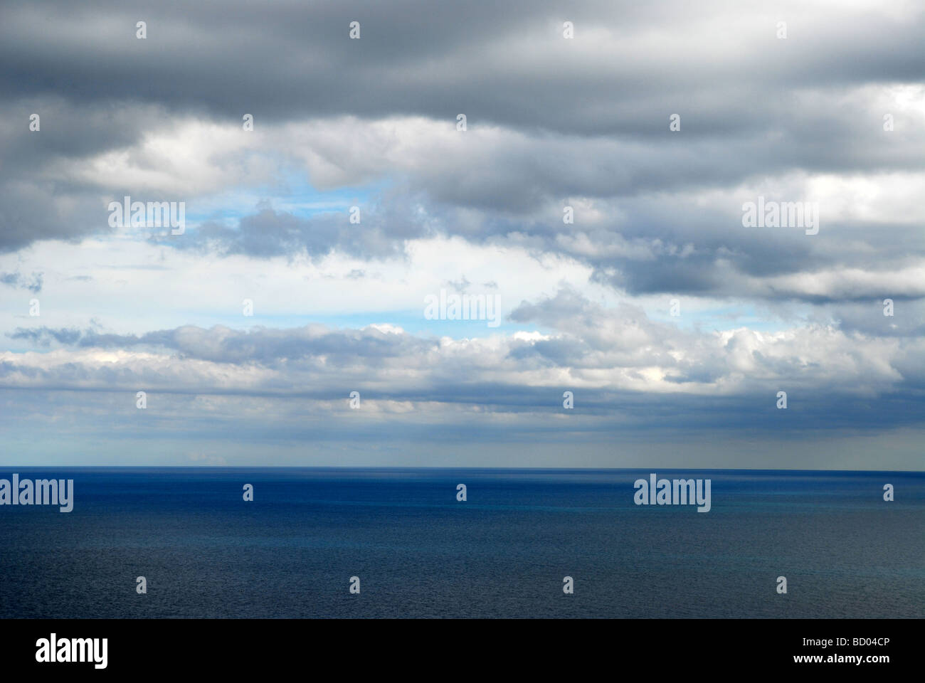 storm clouds reflecting in calm, open sea Stock Photo - Alamy