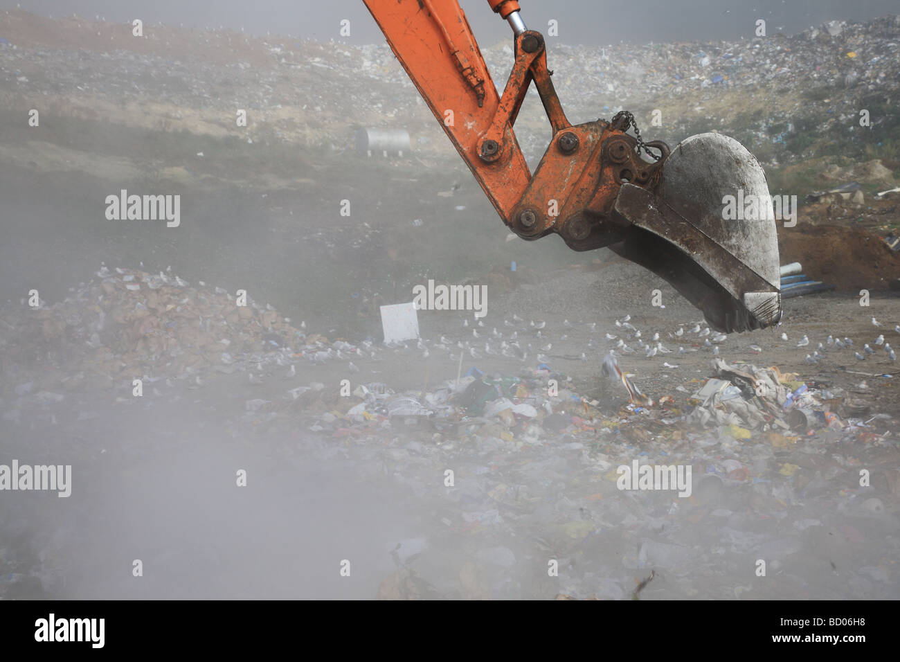 Backhoe atop Trash Stock Photo - Alamy