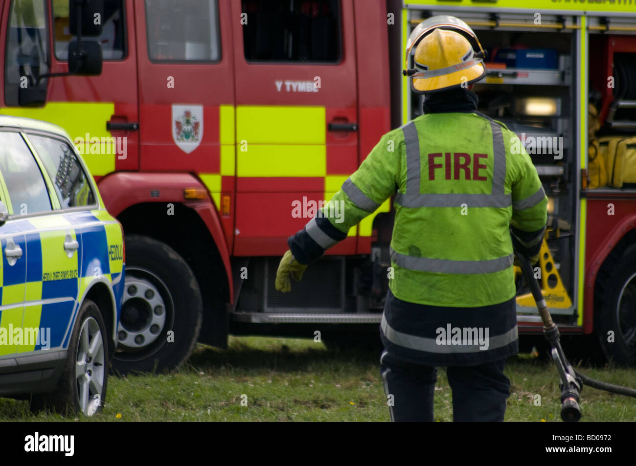 A fireman in front of a fire engine and a police car Stock Photo - Alamy