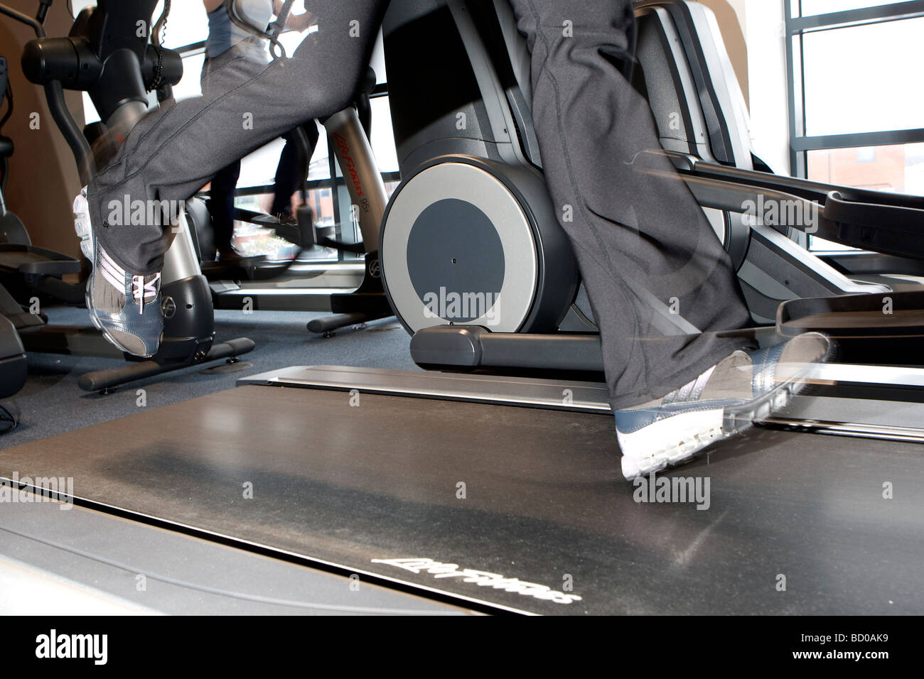 A female runs on a jogging machine in a gym Stock Photo - Alamy