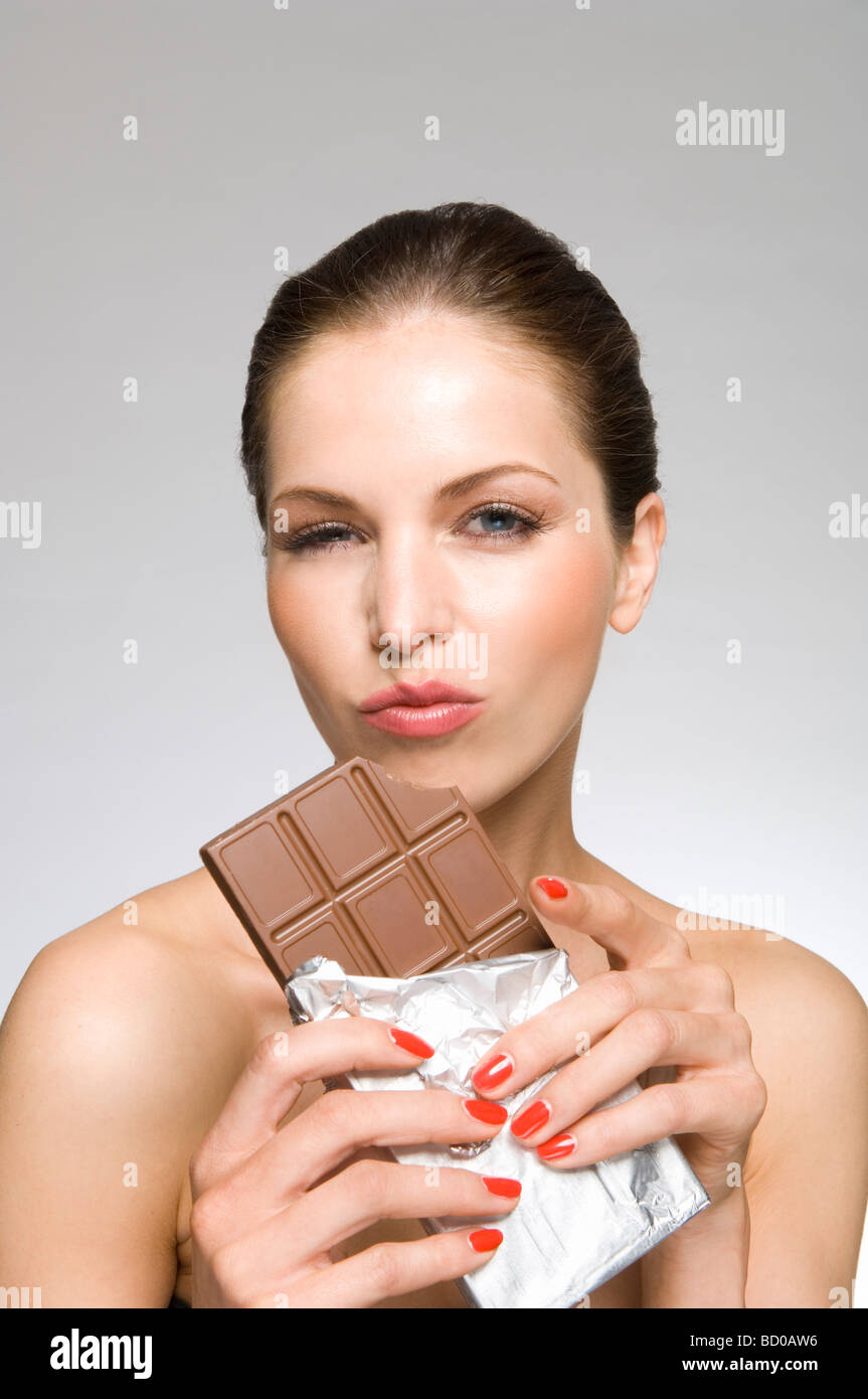 Female beauty model eating chocolate Stock Photo - Alamy